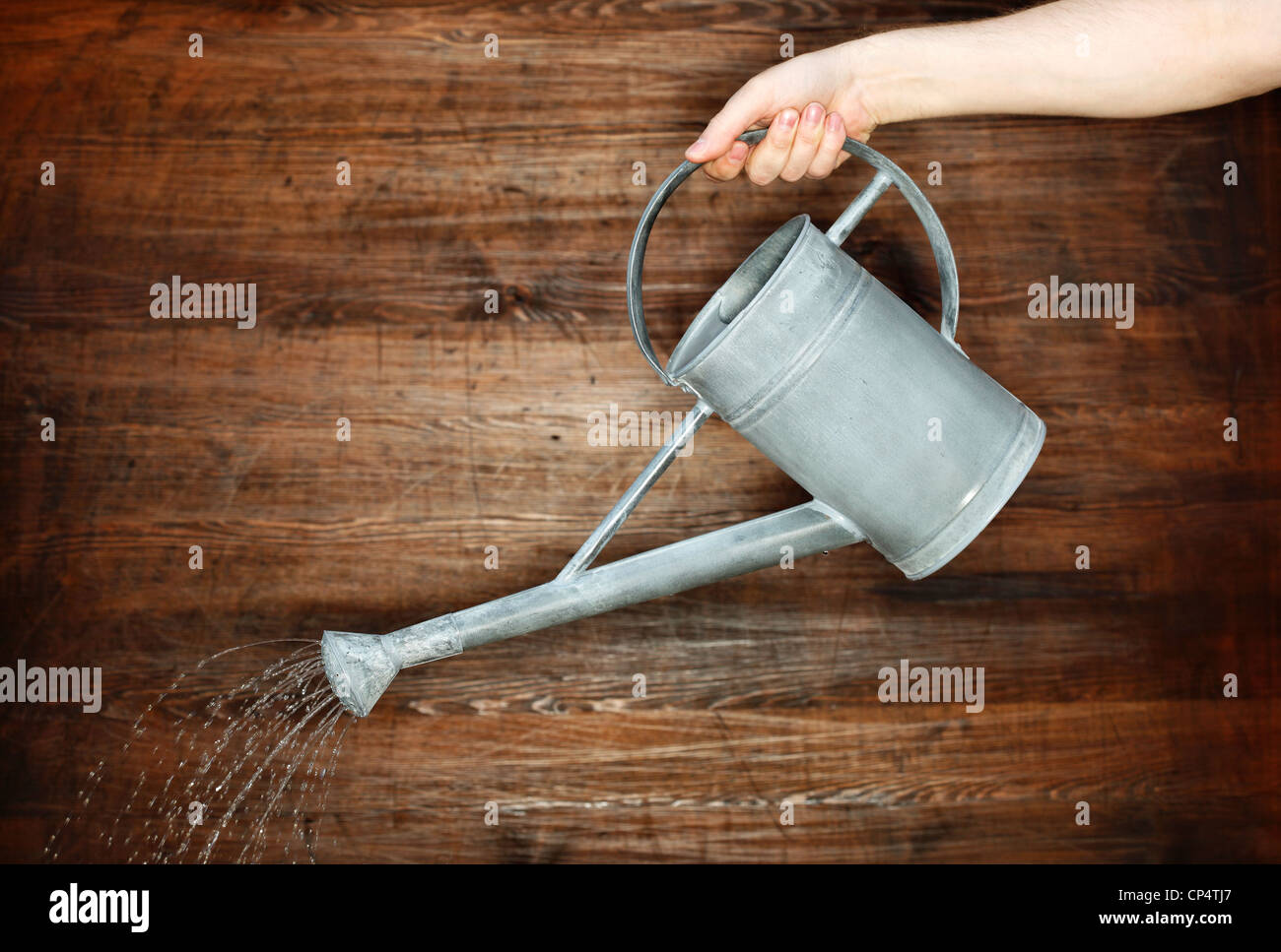 Pouring water with a metallic watering can Stock Photo - Alamy