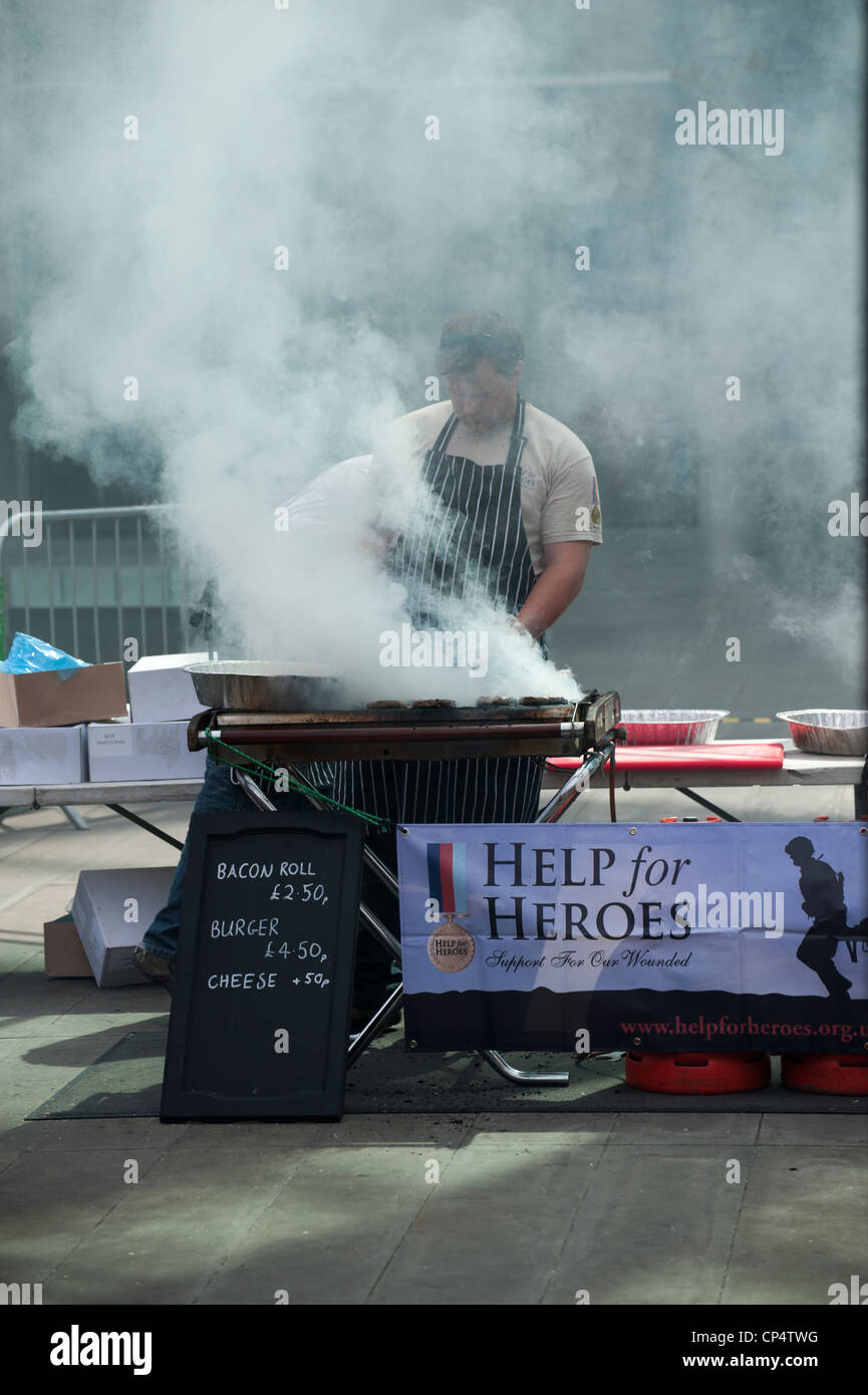 Man cooking on a smoking barbeque at the Help for Heroes charity stand ...