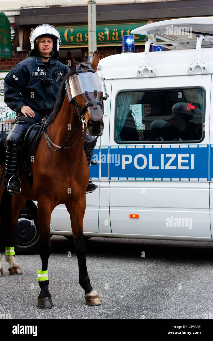 German mounted policewoman in front of a police vehicle at the May Day ...
