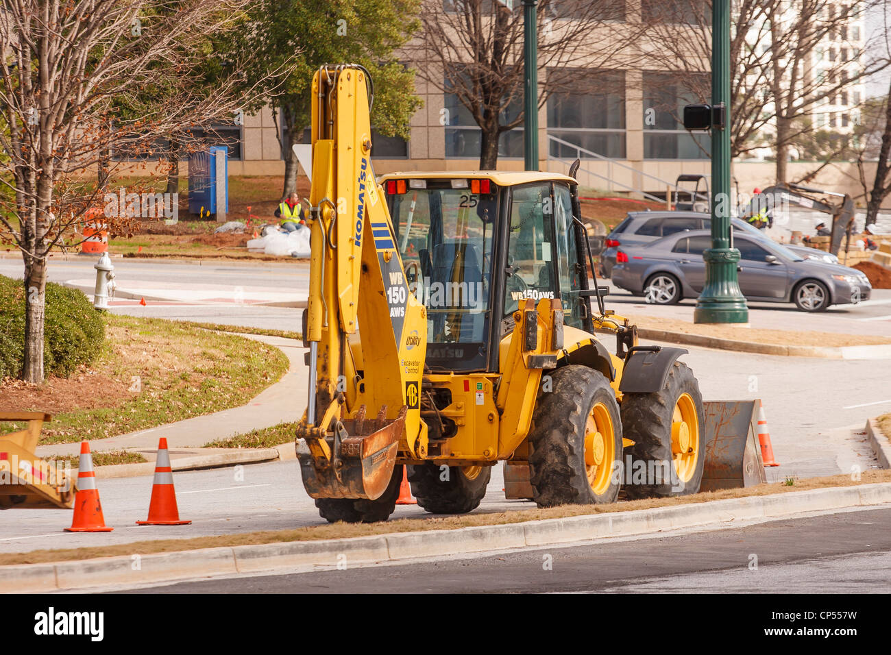 A heavy piece of yellow construction equipment on a road with traffic ...