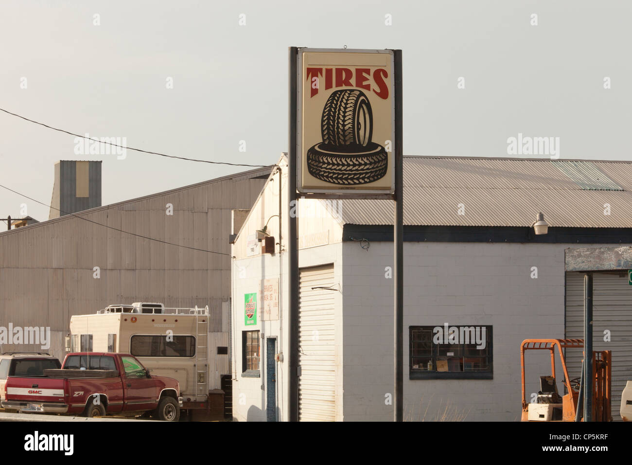 Tire business sign next to building Stock Photo - Alamy