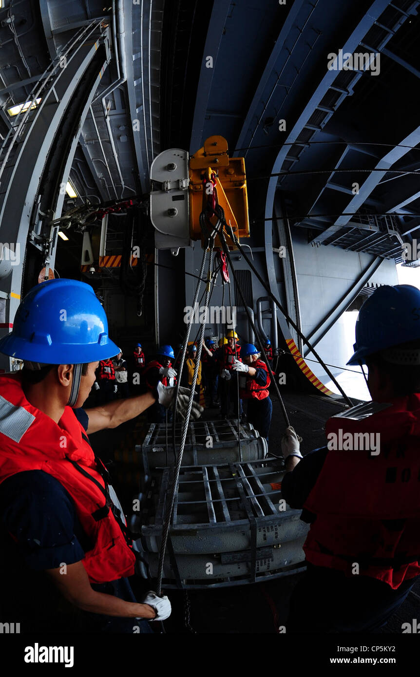 Sailors rig an ordnance pallet in the hangar bay aboard the aircraft ...