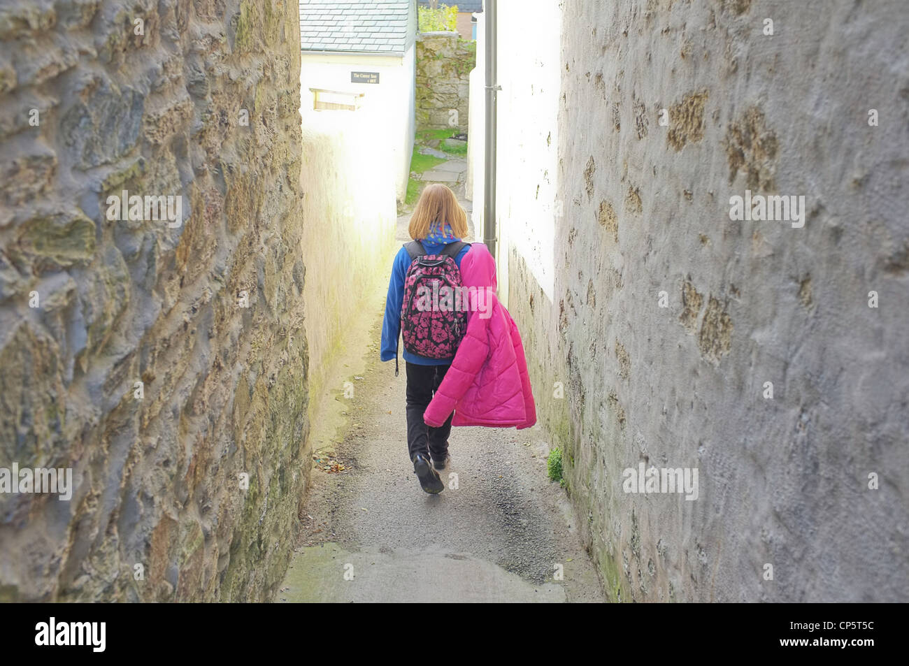 A 9 year old girl walks to school in the rain in Flushing, Cornwall, UK ...