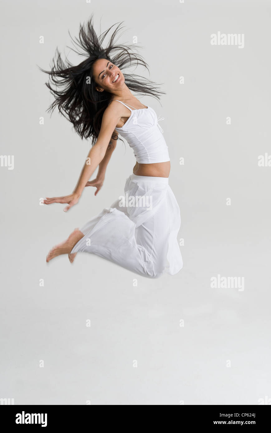 Young woman jumping and dancing, smiling, portrait Stock Photo - Alamy