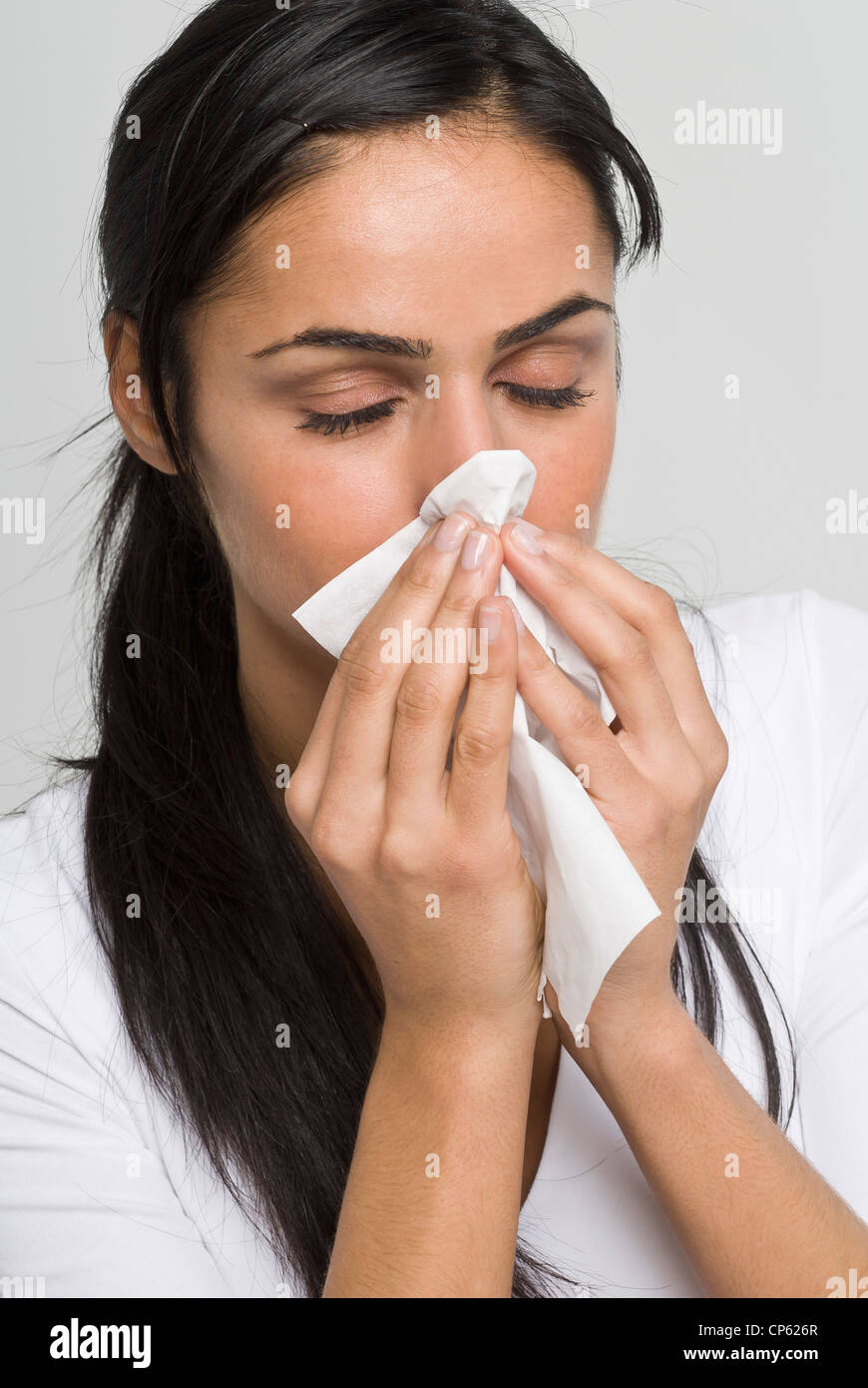 Young woman blowing her nose in handkerchief Stock Photo - Alamy