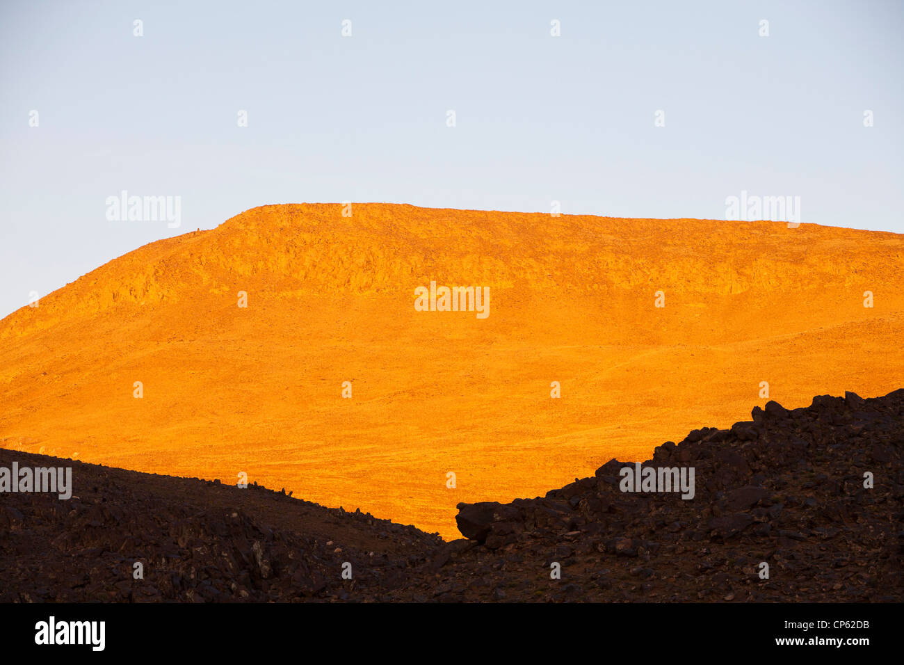 Warm sunlight at sunset lighting a small peak in the Anti atlas ...