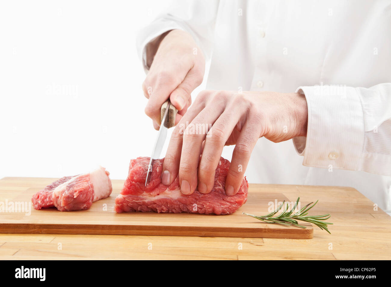 Man cutting meat on chopping board Stock Photo - Alamy