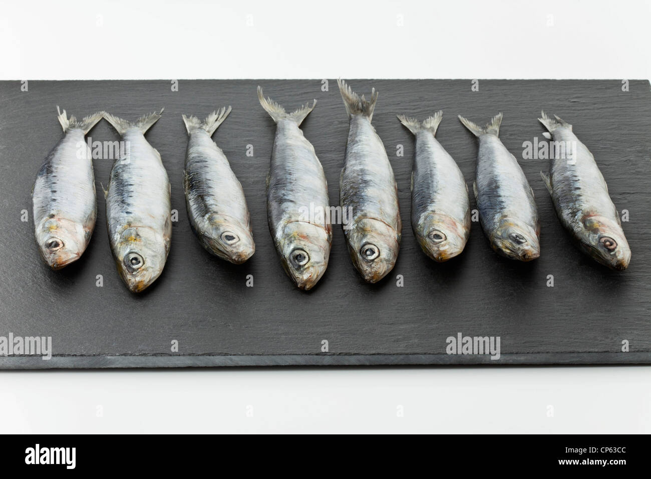 Sardines on chopping board Stock Photo - Alamy