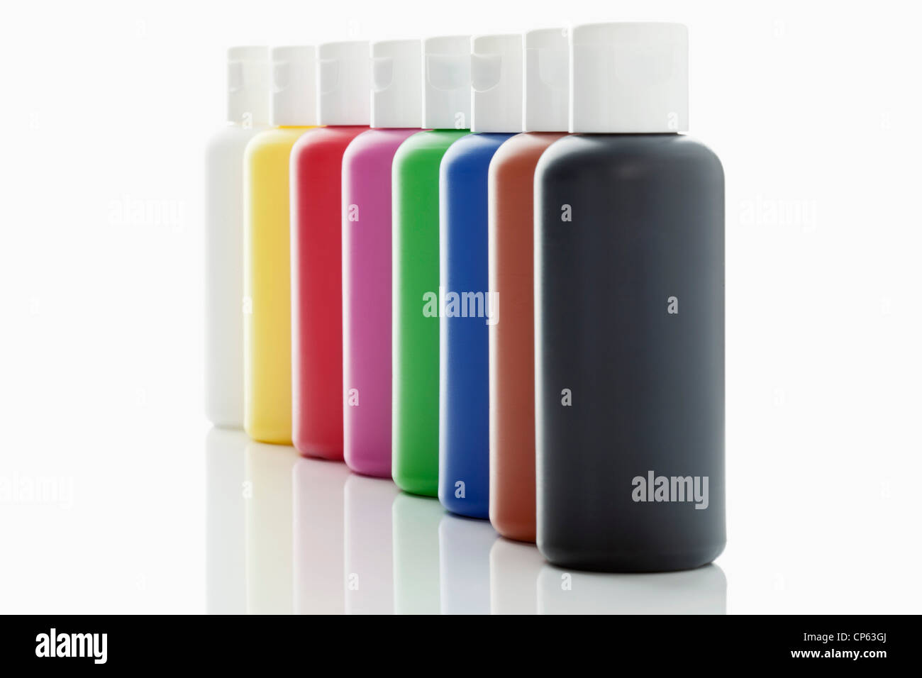 Row of acrylic color bottles on white background Stock Photo - Alamy