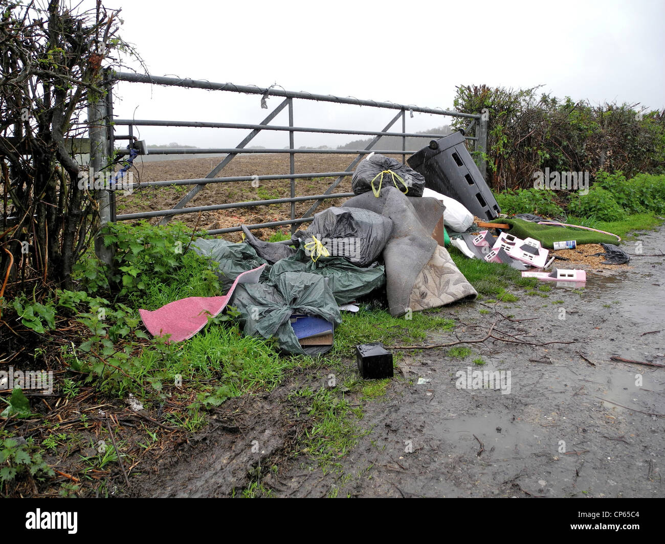 Fly tipping tip in gateway in UK countryside Stock Photo - Alamy