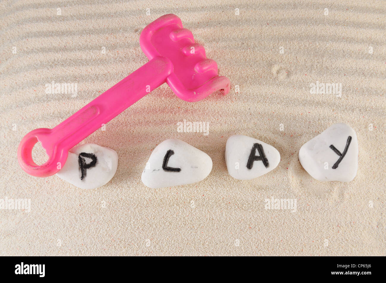 Play word on group of stones with sand as background Stock Photo - Alamy
