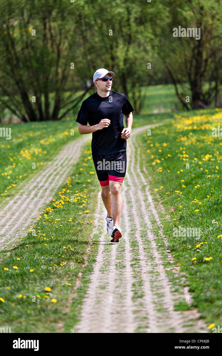 a young man jogging through the fields Stock Photo - Alamy