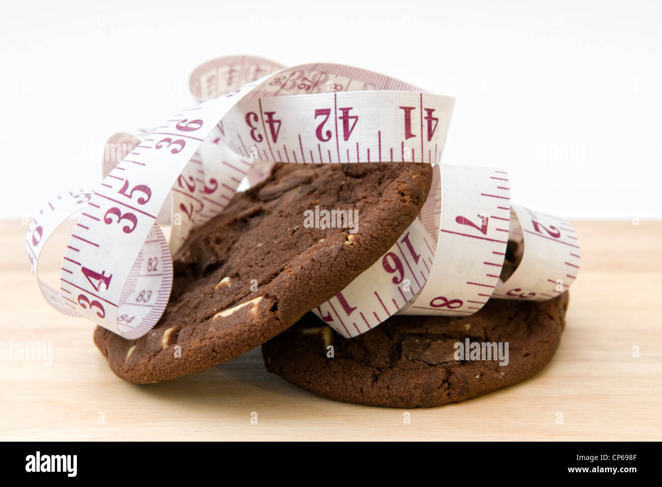 Cookies on chopping board with tape measure depicting concept that ...