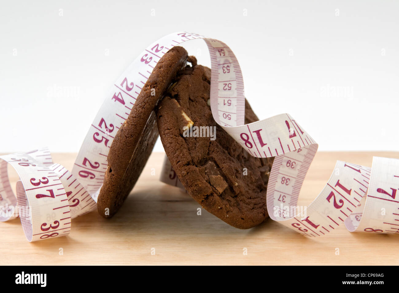 Cookies on chopping board with tape measure depicting concept that ...
