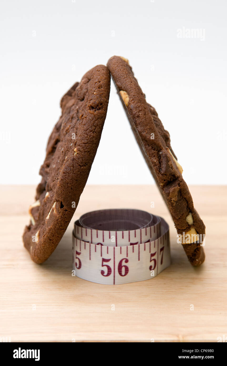Cookies on chopping board with tape measure depicting concept that ...