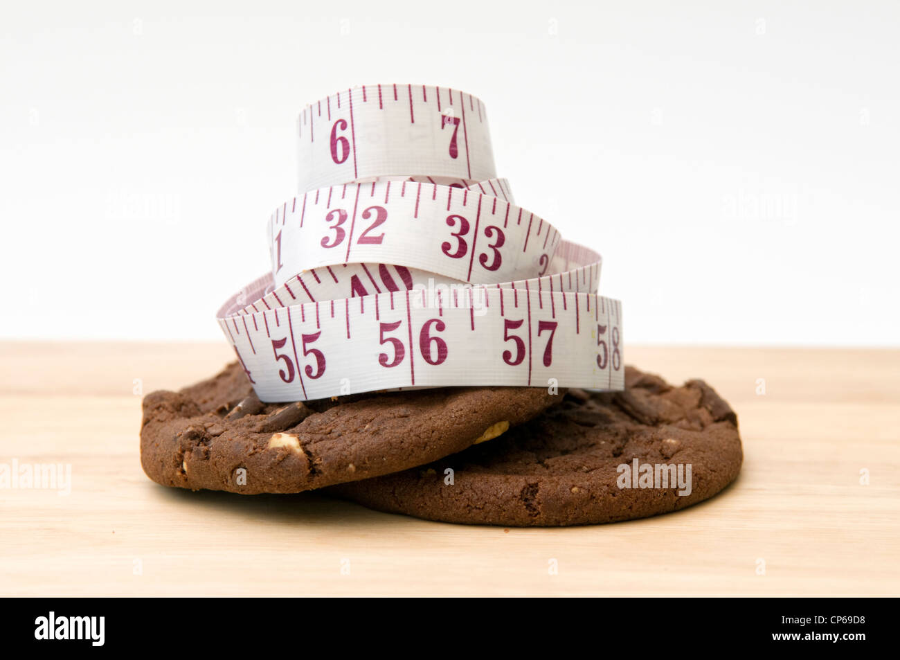 Cookies on chopping board with tape measure depicting concept that ...