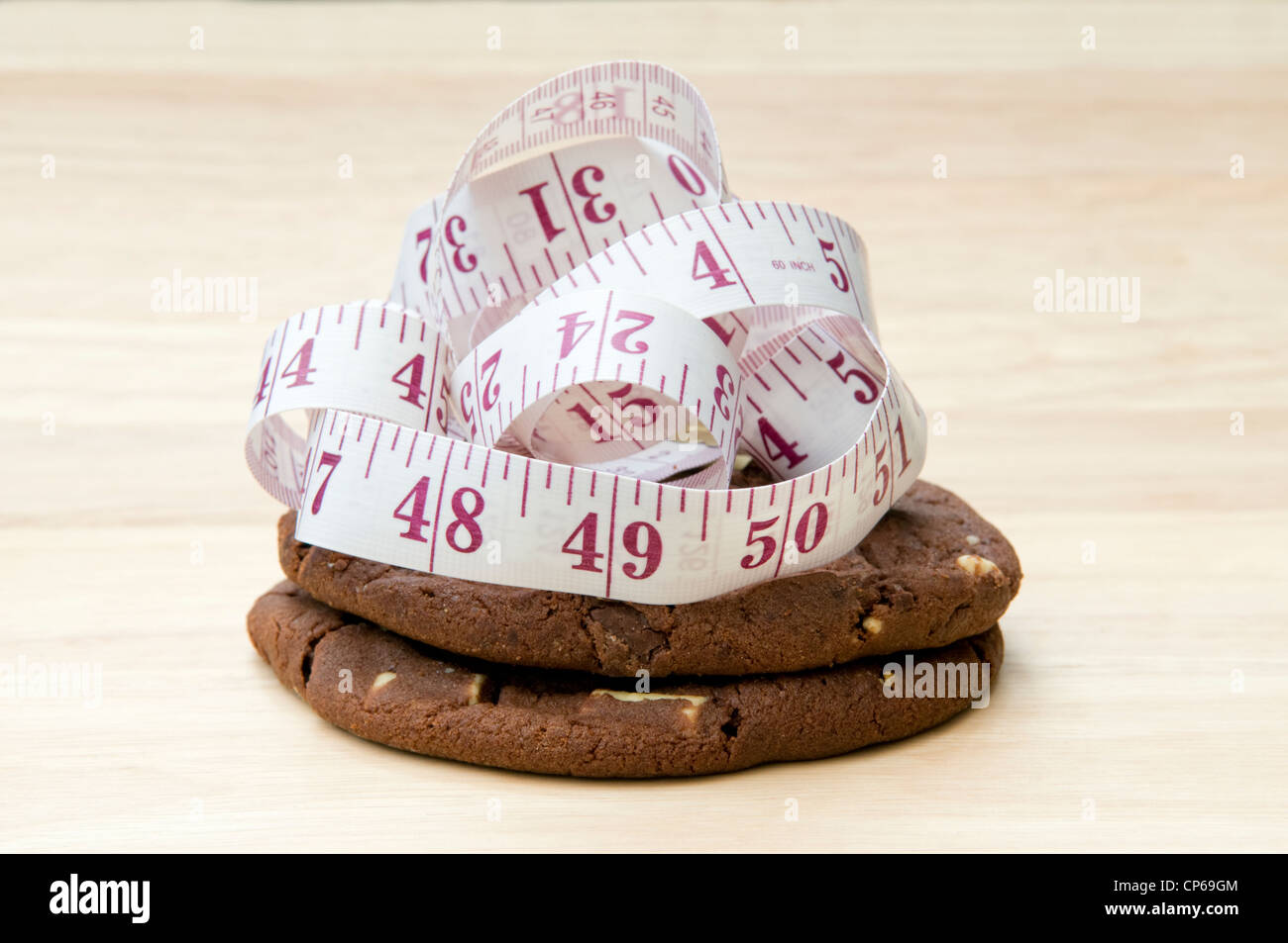 Cookies on chopping board with tape measure depicting concept that ...