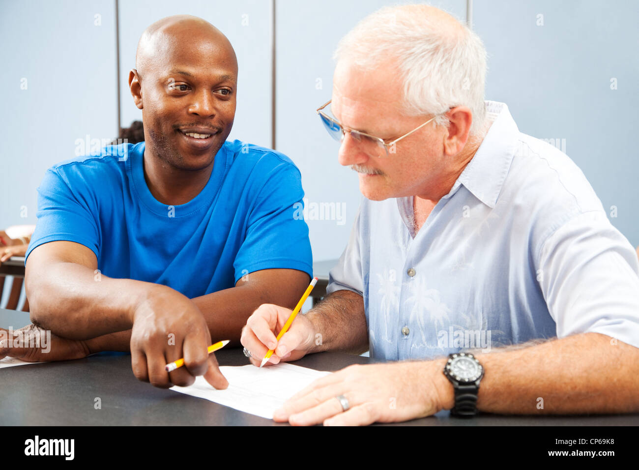 Young college student tutoring an older classmate Stock Photo - Alamy