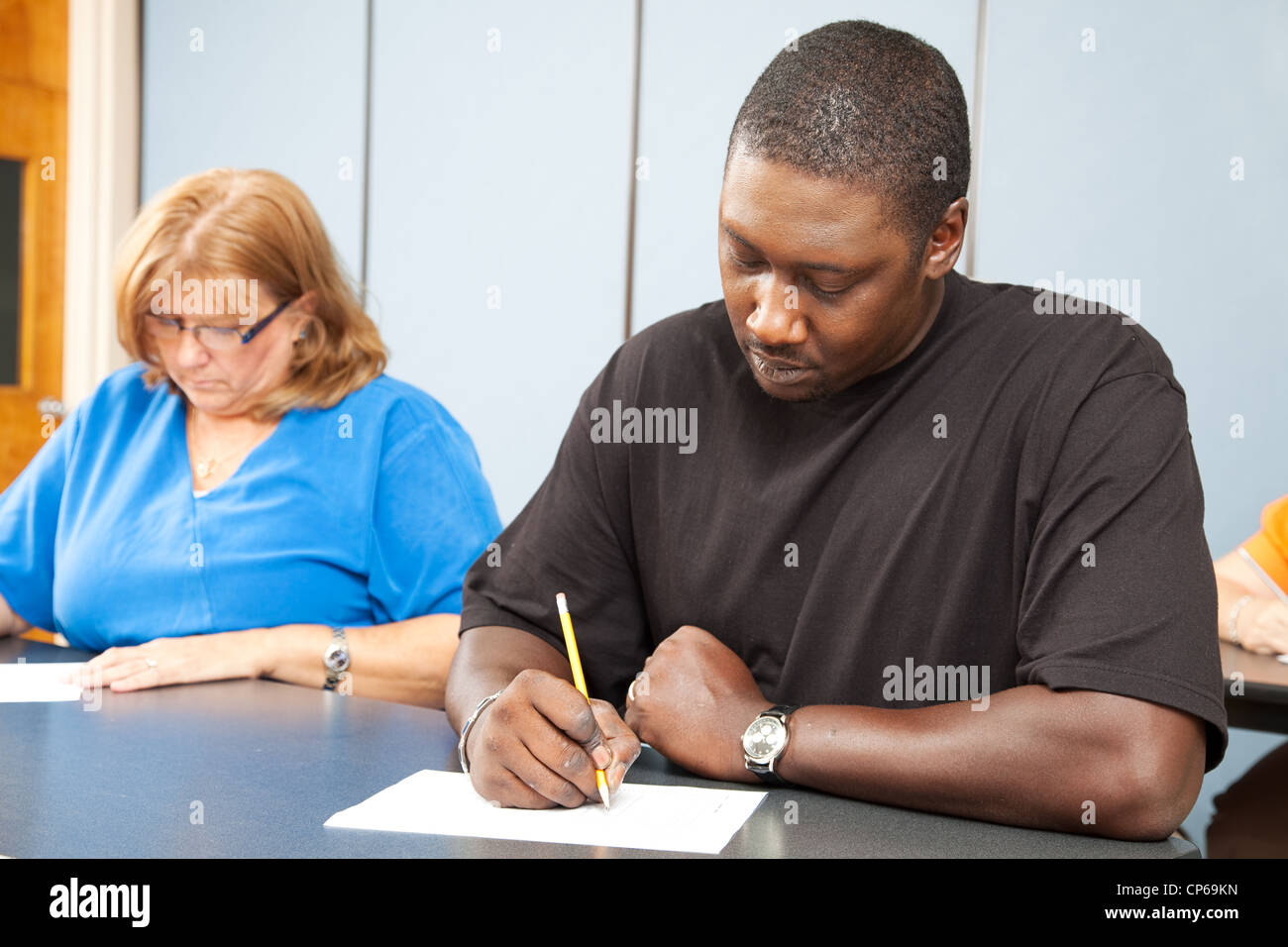 Diverse adult education students taking a test in class Stock Photo - Alamy