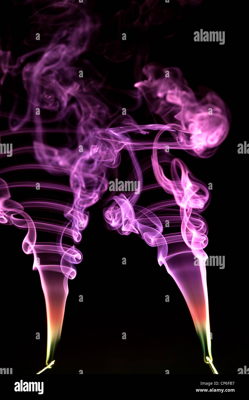 Two near identical smoke patterns formed from incense and colored gels ...