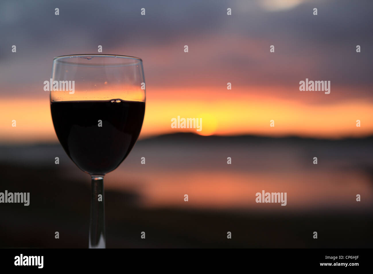 Glass of red wine against a stunning sunset Stock Photo - Alamy