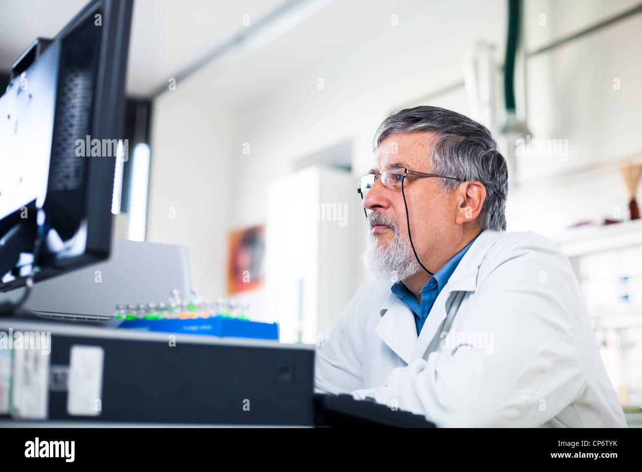 Senior researcher using a computer in the lab while working on an ...