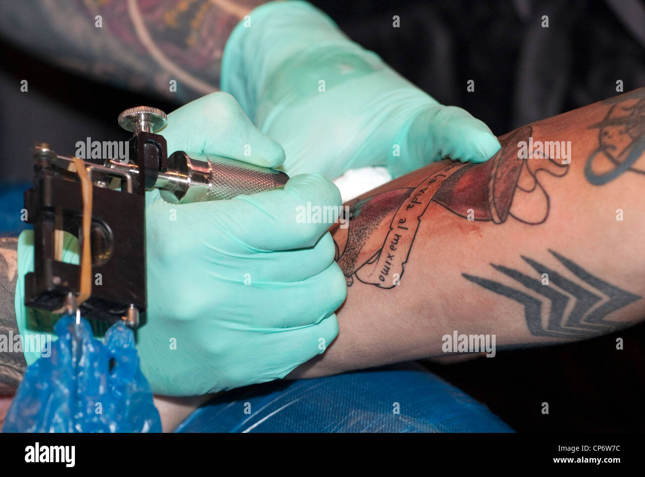 Tattoo artist at work on the hand Stock Photo - Alamy