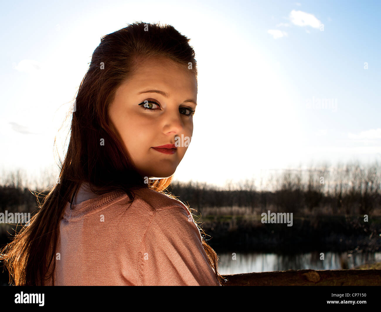 Woman looking back with light behind her Stock Photo - Alamy