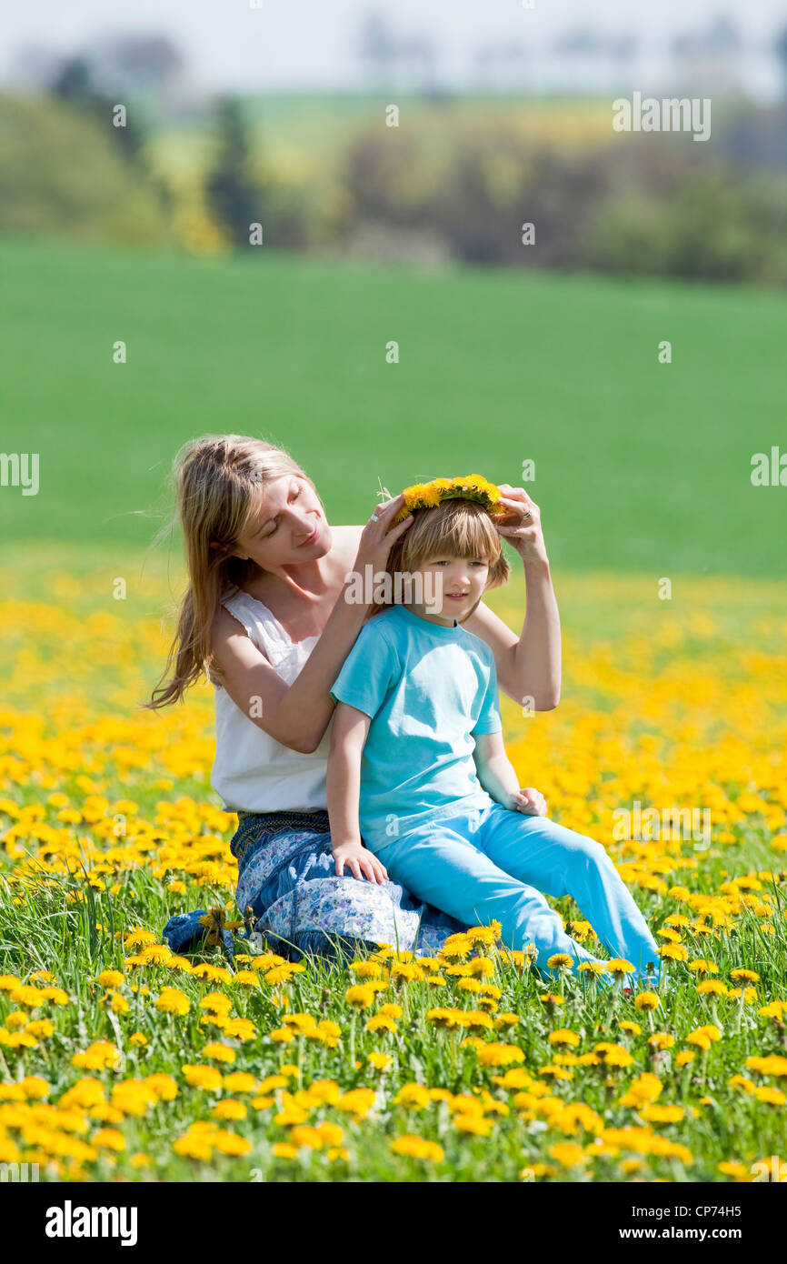 mother and son picking flowers at dandelions field in spring Stock ...