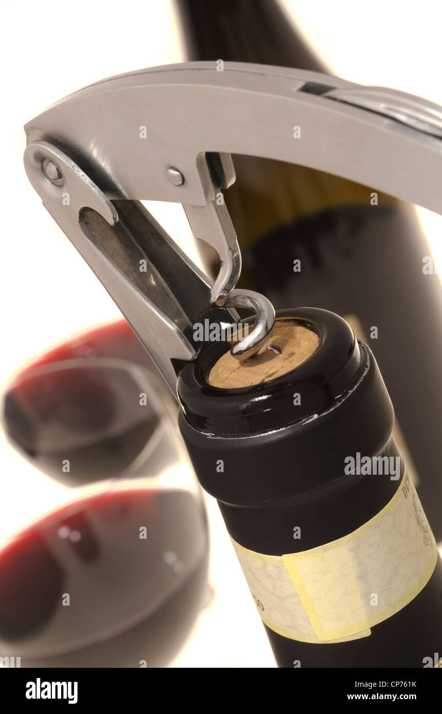 Opening a wine bottle and two wine glasses at background.(Shallow DOF ...