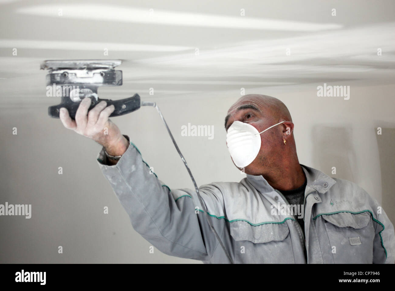 Man putting up a plasterboard ceiling Stock Photo - Alamy
