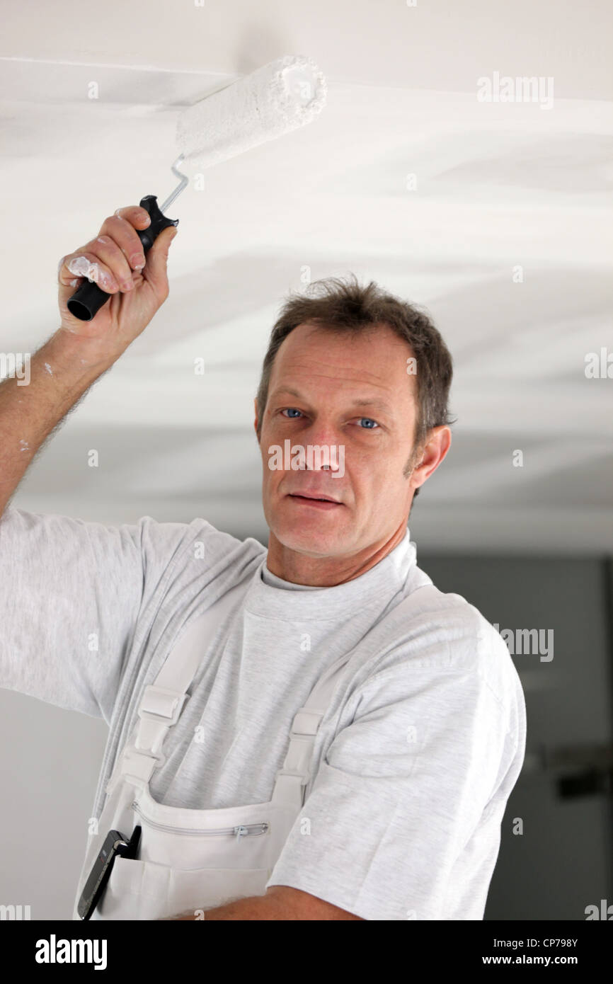 Decorator painting ceiling Stock Photo - Alamy