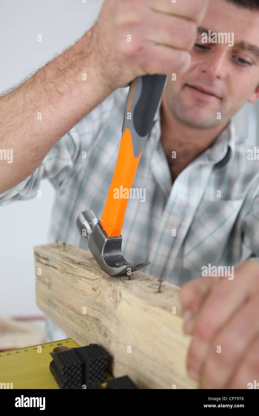 Man removing nails using his hammer Stock Photo - Alamy
