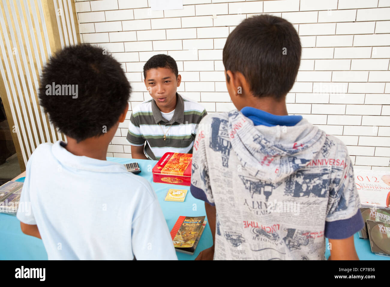 Boy selling Catholic merchandise during a 3 hour baptism ceremony at ...