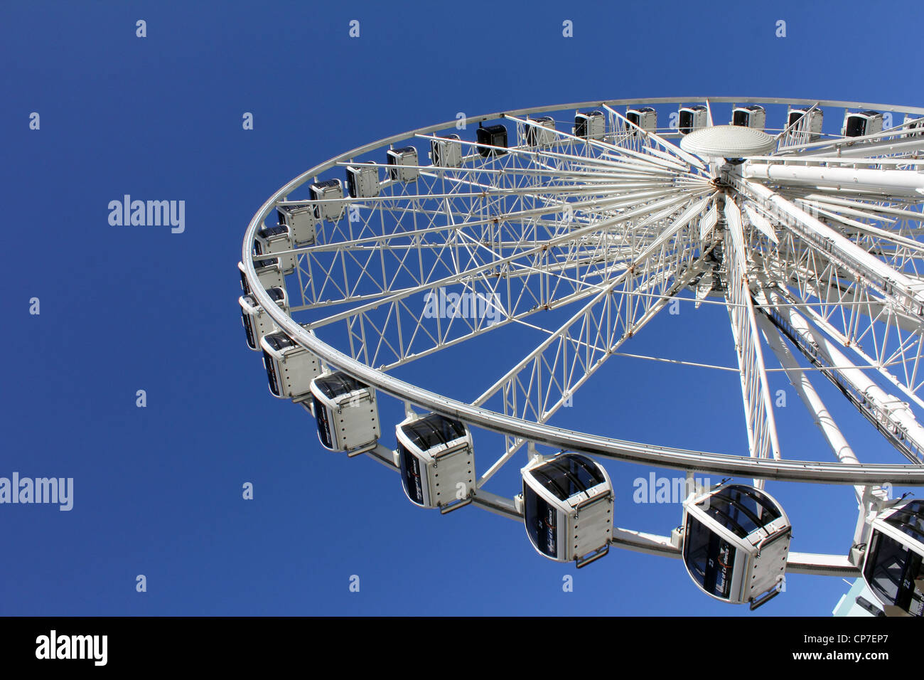 WIDE VIEW OF A EMPTY WHITE FERRIS WHEEL AGAINST BLUE SKY BACKGROUND BDB ...