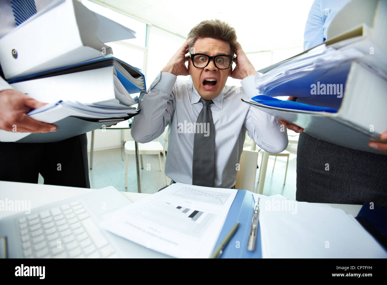 Terrified accountant touching his head being surrounded by huge piles ...