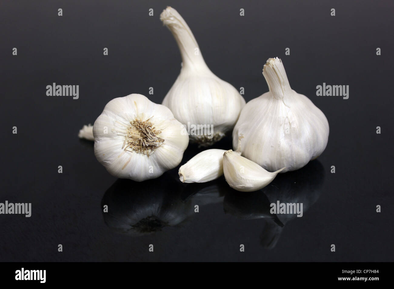 A bulb of garlic (Allium sativum)and cloves in black background Stock ...