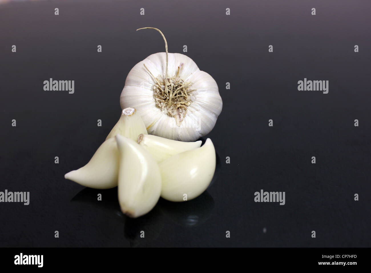 A bulb of garlic (Allium sativum)and cloves in black background Stock ...