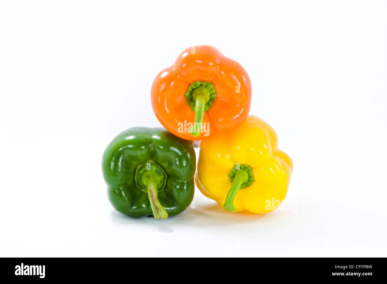 Pyramid formed of three green, yellow and orange colored bell peppers ...