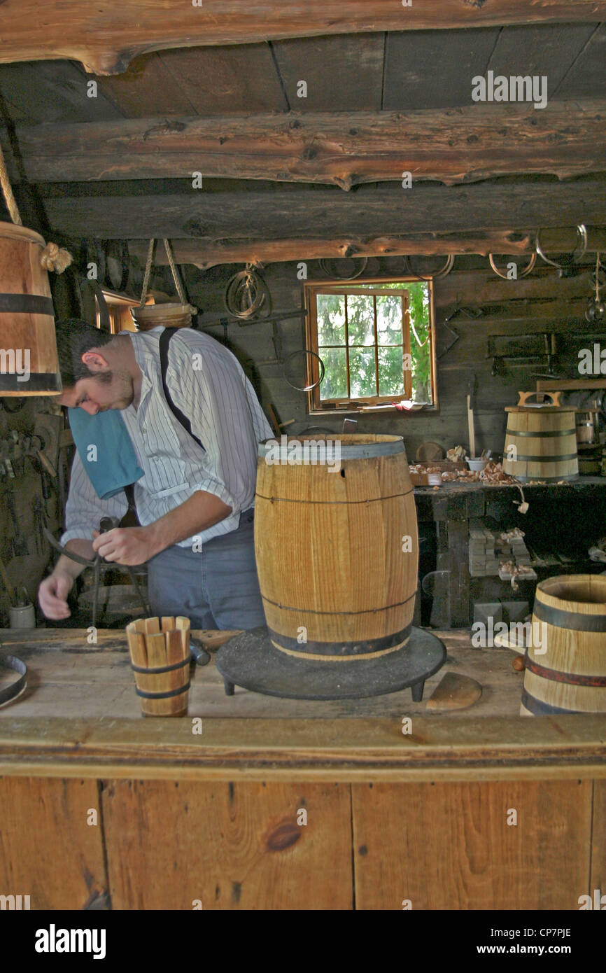 A male Barrel maker is working at Pioneer Village with historical ...