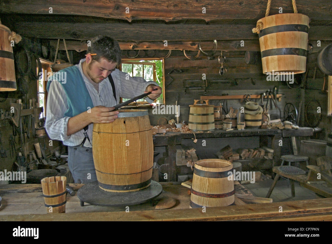 Male Barrel maker working in Pioneer Village with historical buildings ...