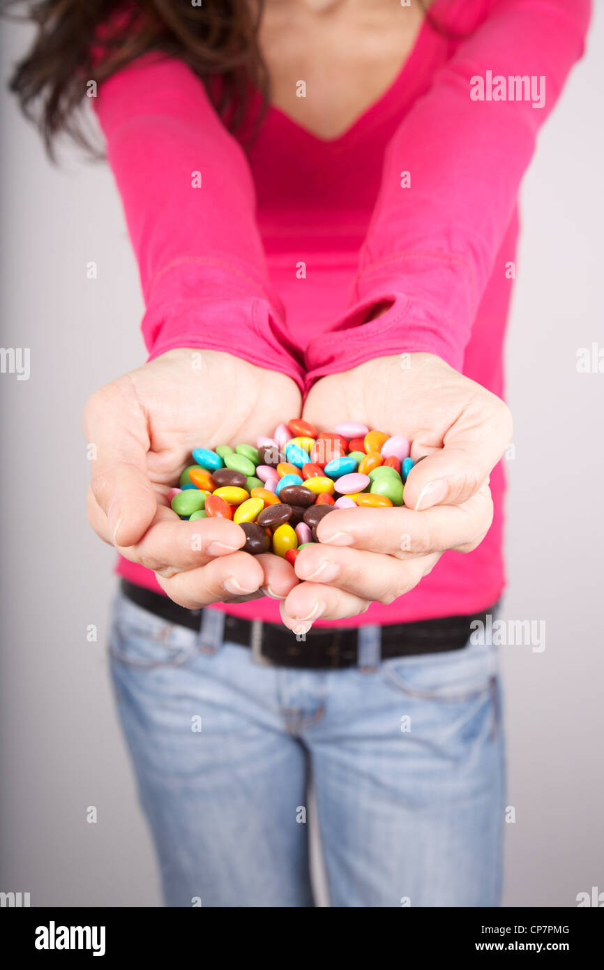 woman portrait holding lot of candy in her hands Stock Photo - Alamy