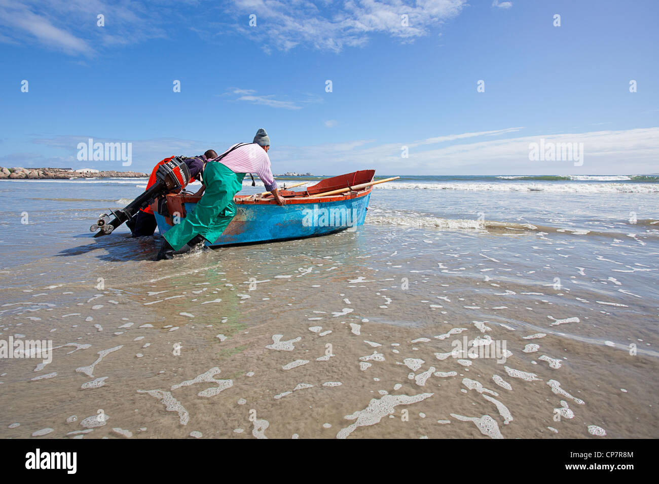Two fishermen launching small fishing boat in Paternoster Stock Photo ...