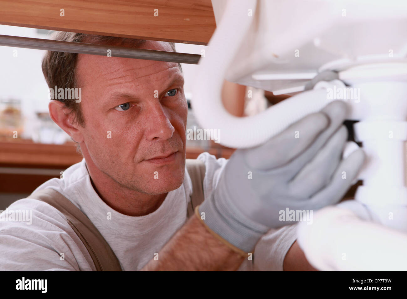 Plumber fixing a sink Stock Photo - Alamy