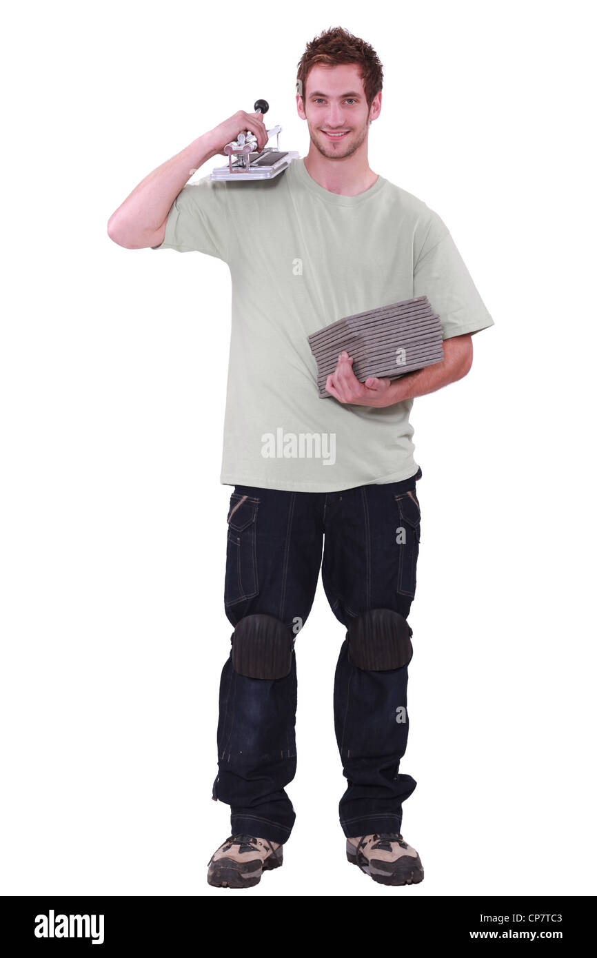 a young man holding tiles and a tiles cutter Stock Photo - Alamy