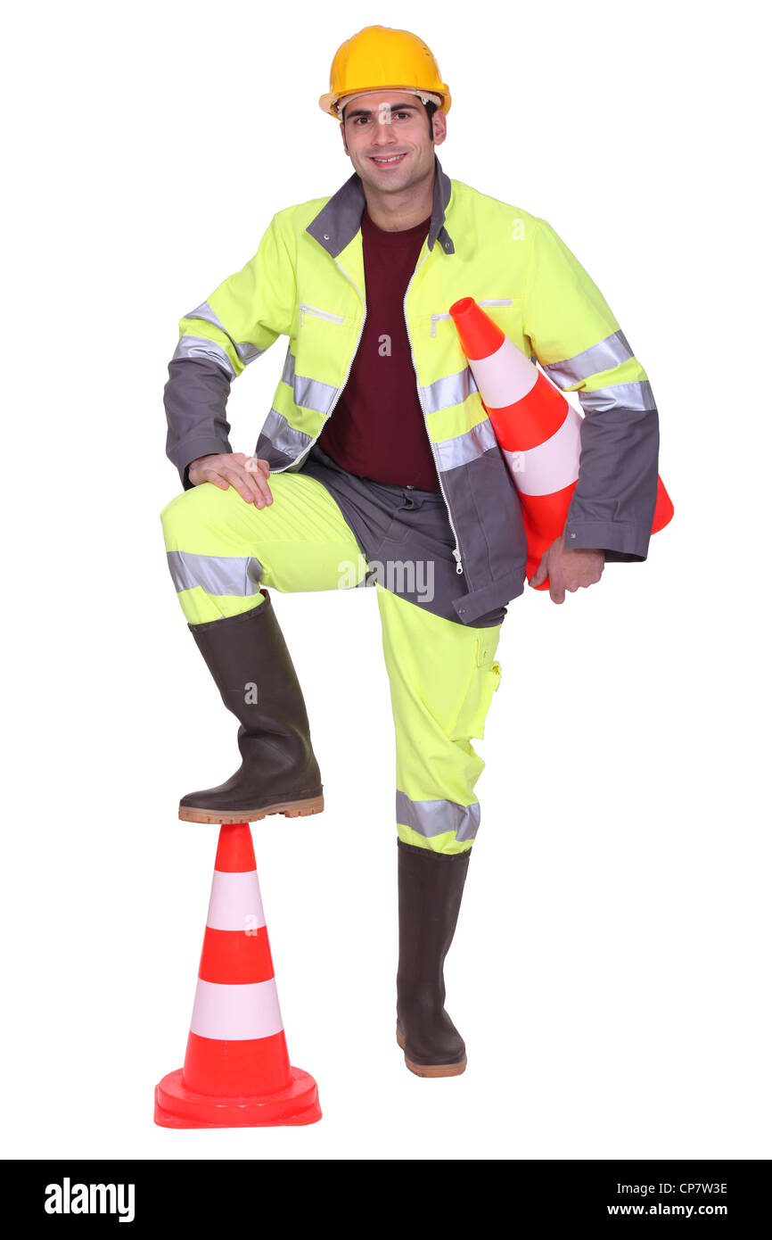 Worker with foot on top of cone signaling Stock Photo - Alamy