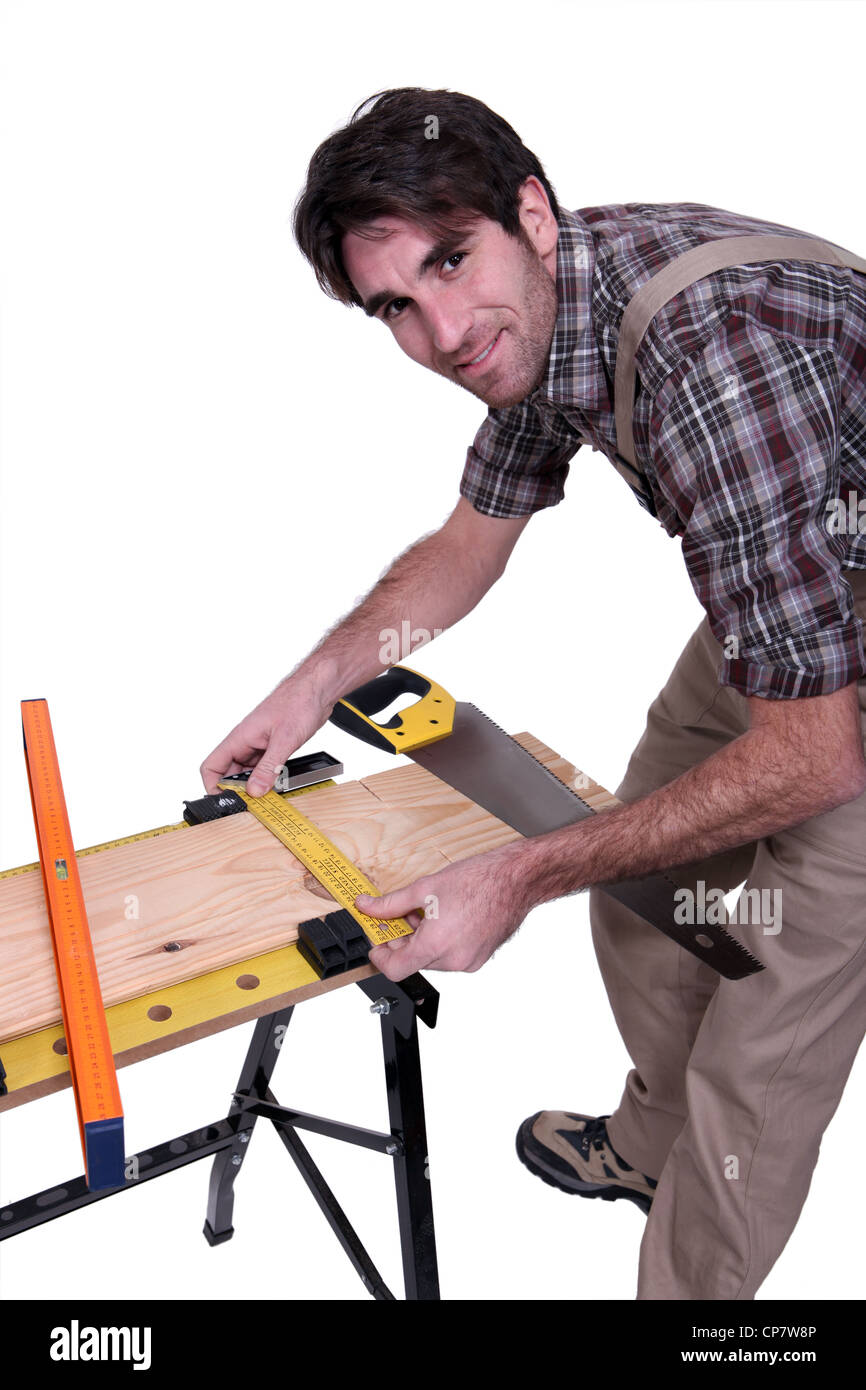 Carpenter measuring wood on a workbench Stock Photo - Alamy