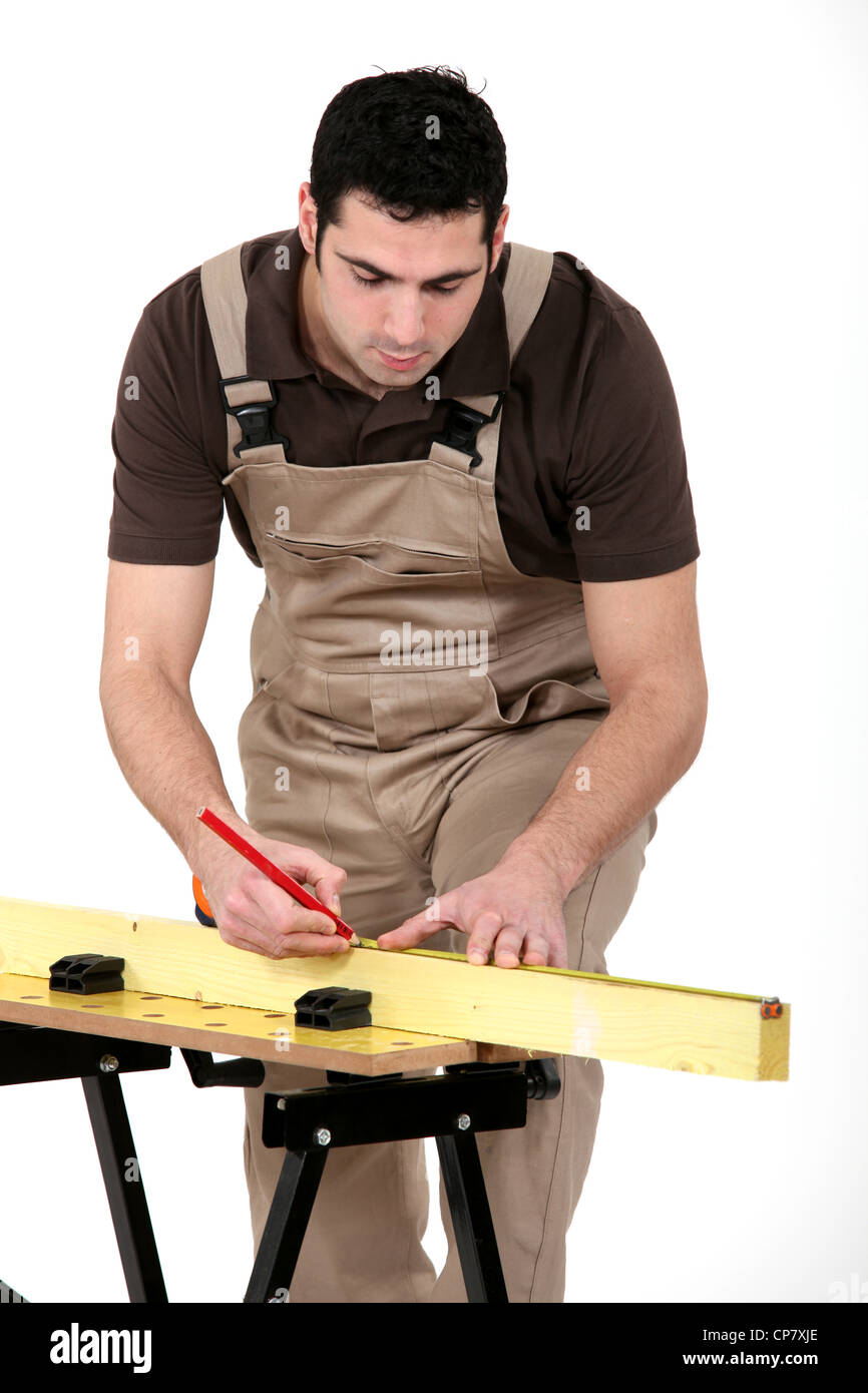 Man measuring plank of wood Stock Photo - Alamy