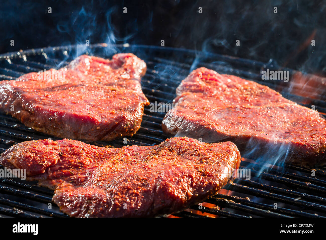 BBQ with fiery steak on the grill Stock Photo - Alamy