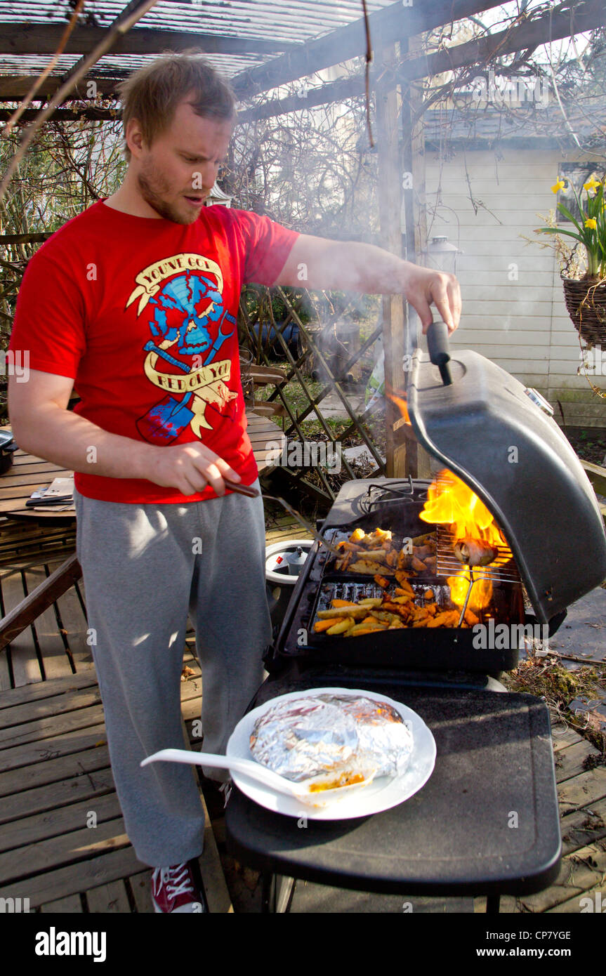 man grilling barbeque food.Grill sets in flames Stock Photo - Alamy